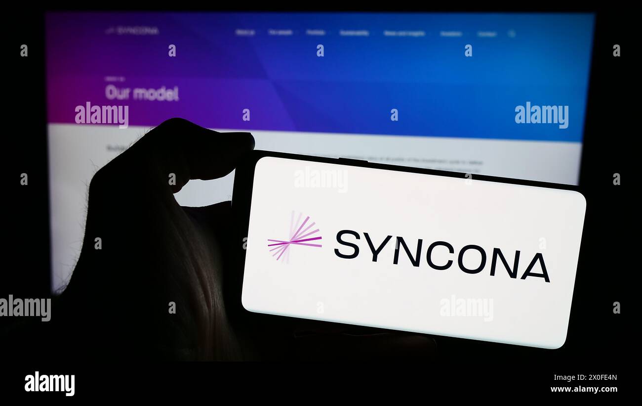 Person holding smartphone with logo of British investment company ...