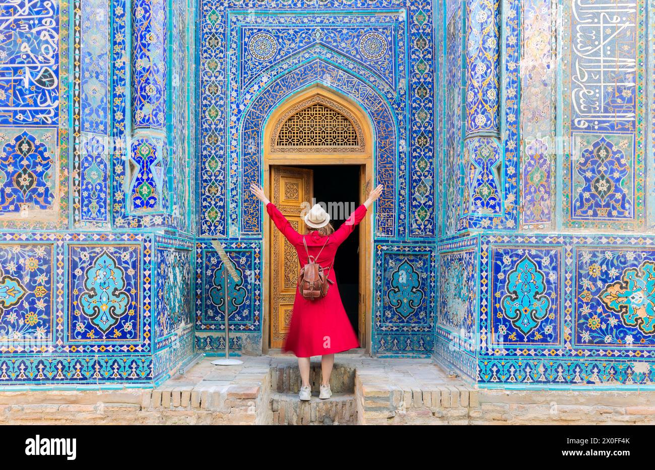tourist woman in red dress clothes stands near an ancient architectural ...