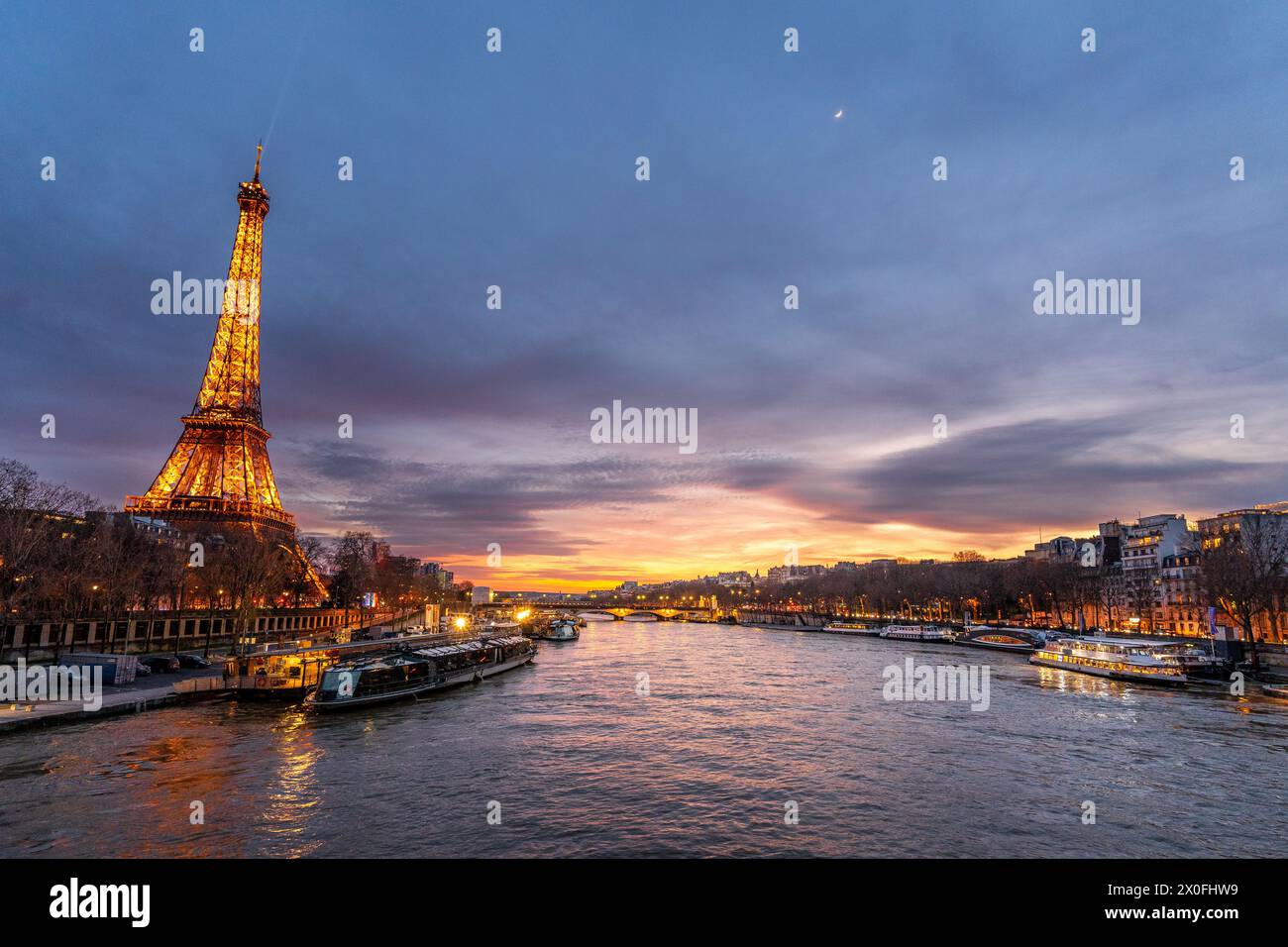Eiffel Tower at sunset, with the Parisian cityscape in the background ...