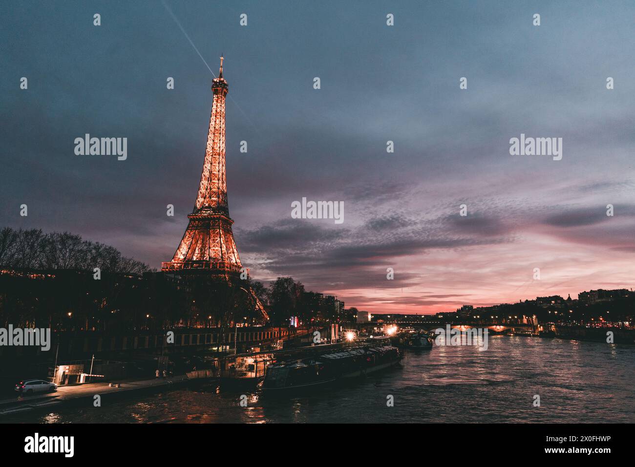Eiffel Tower at sunset, with the Parisian cityscape in the background ...