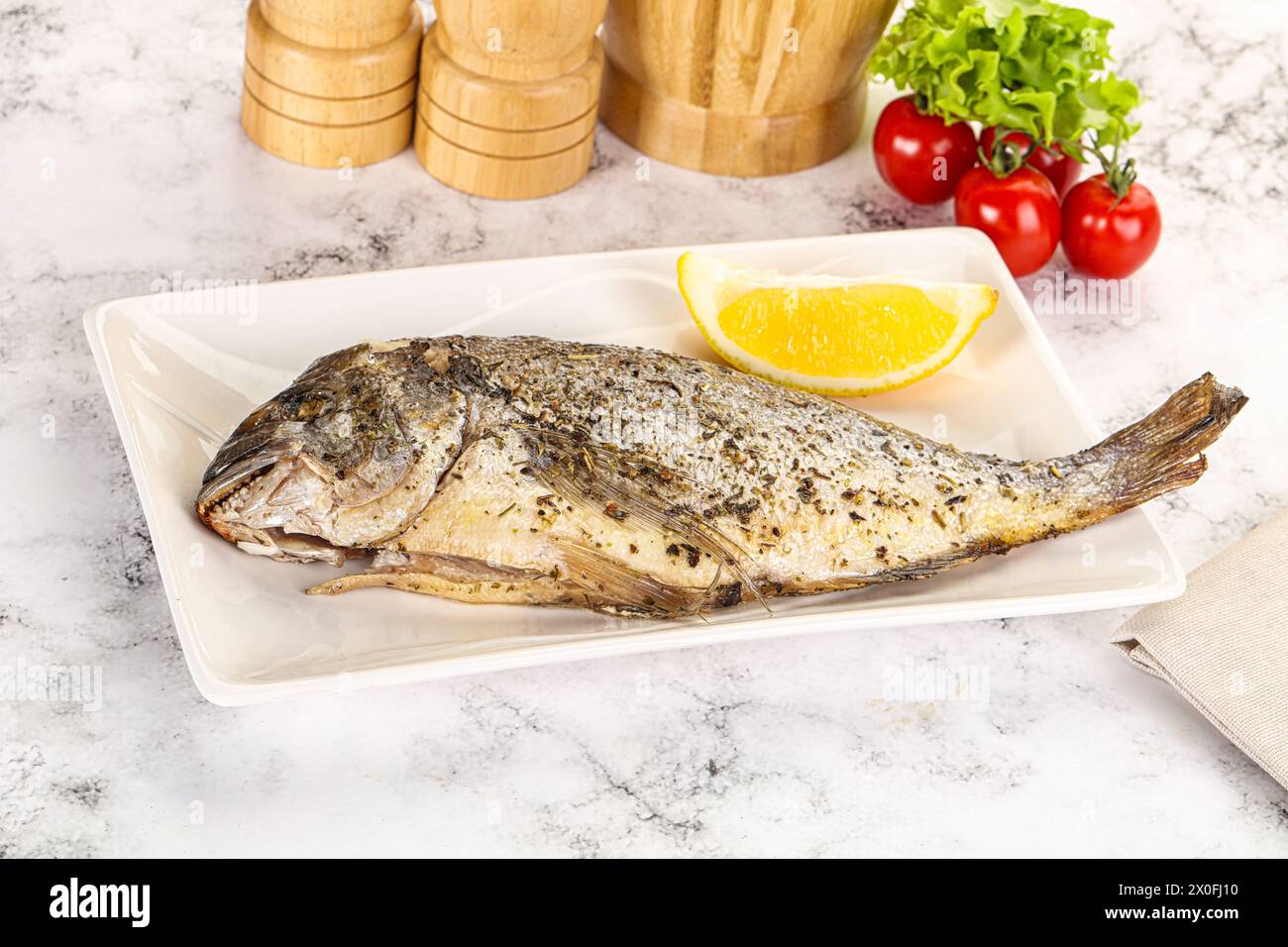Baked Dorado fish served lemon slice Stock Photo - Alamy
