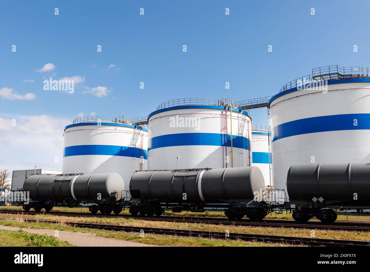 Row many large industrial fuel storage white tanks clear blue sky ...