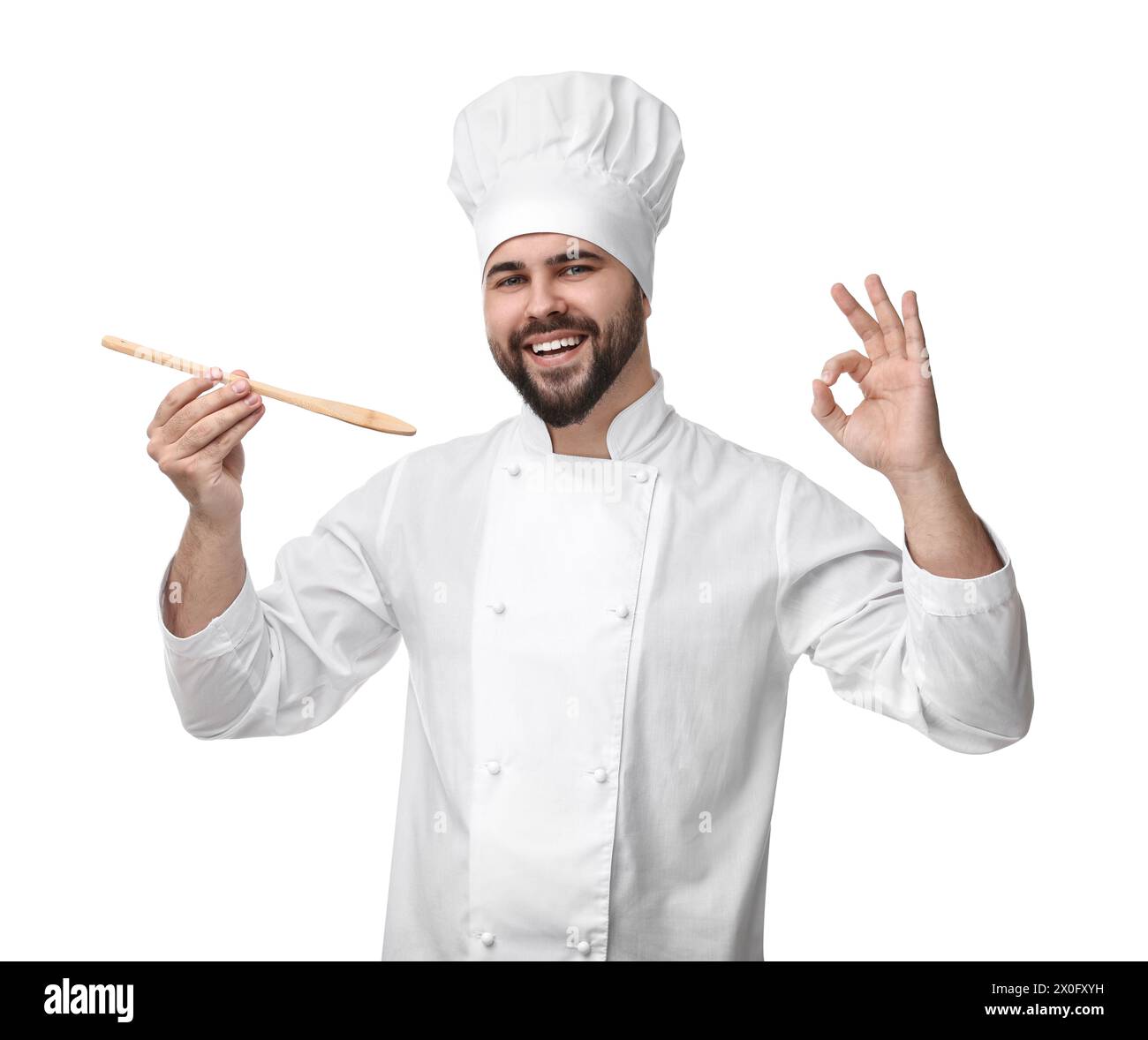 Happy young chef in uniform tasting something and showing ok gesture on ...