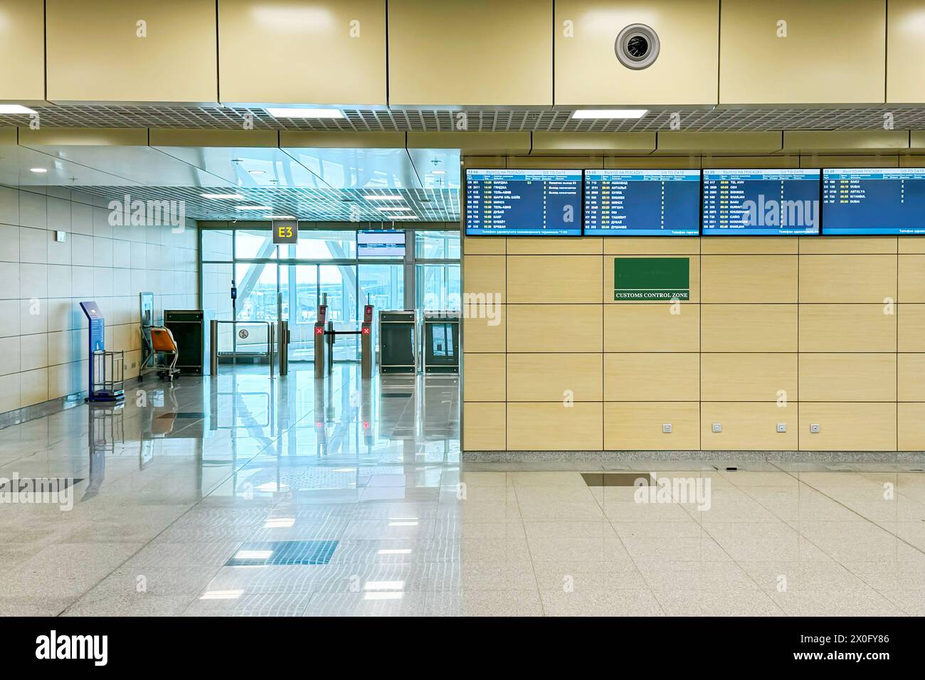 Brightly lit airport terminal with spacious area with gleaming tiled ...