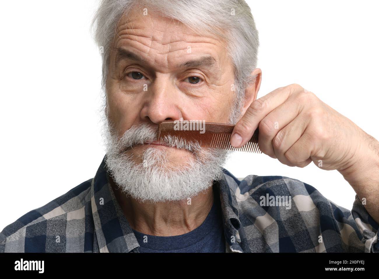 Senior man combing beard with comb on white background Stock Photo - Alamy