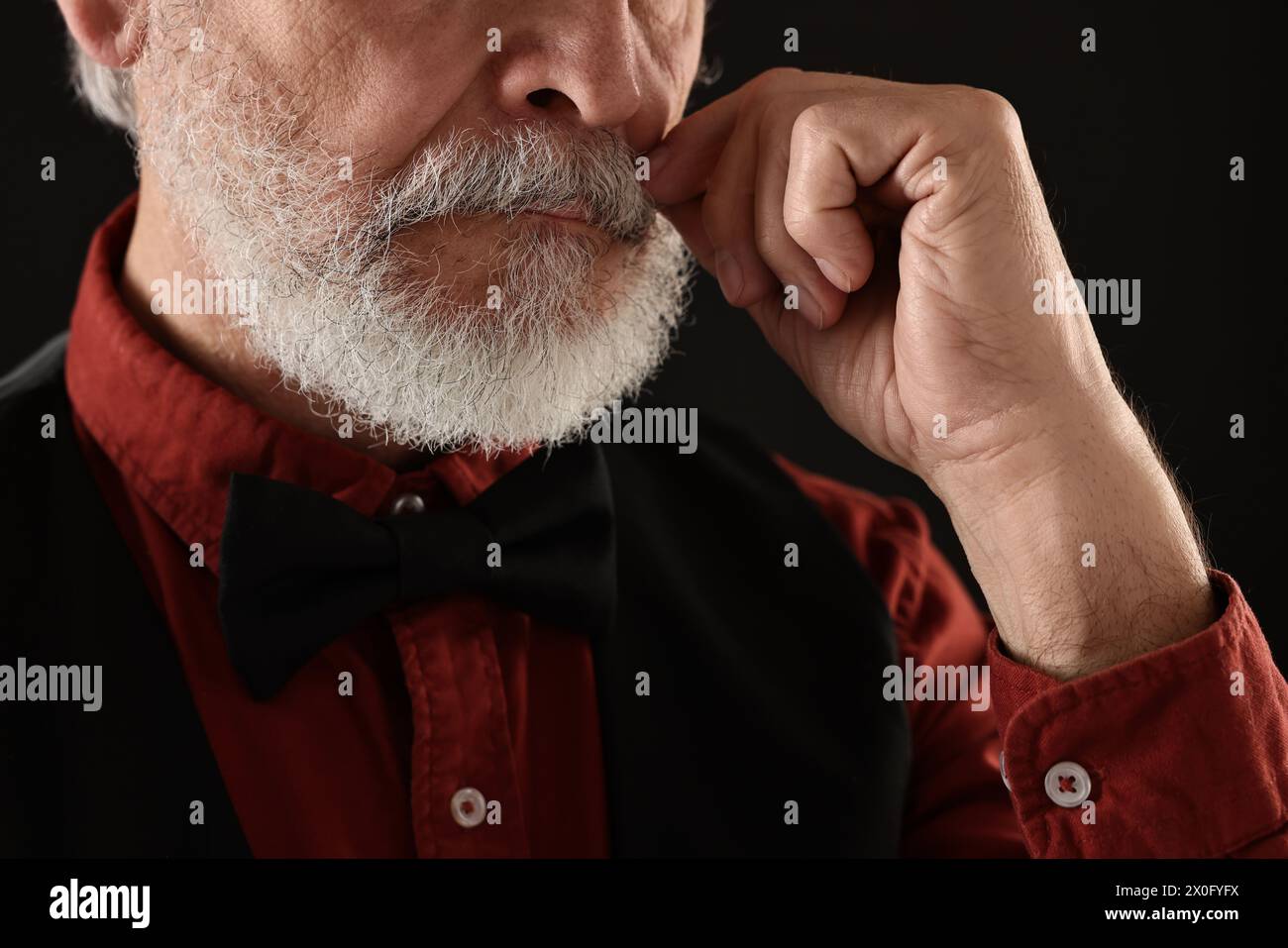 Man touching mustache on black background, closeup Stock Photo - Alamy