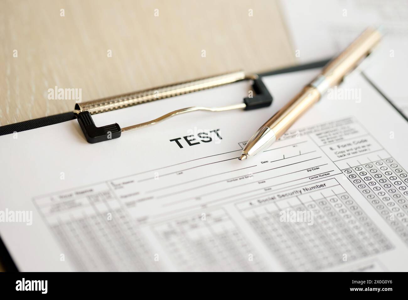 Blank educational test for students lies on table in classroom with pen ...