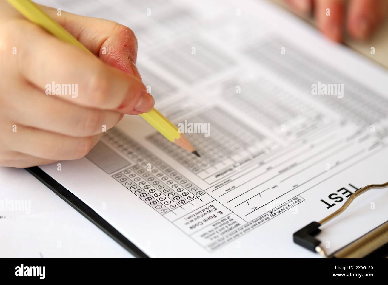 Female student hands testing in exercise and taking fill in exam paper ...