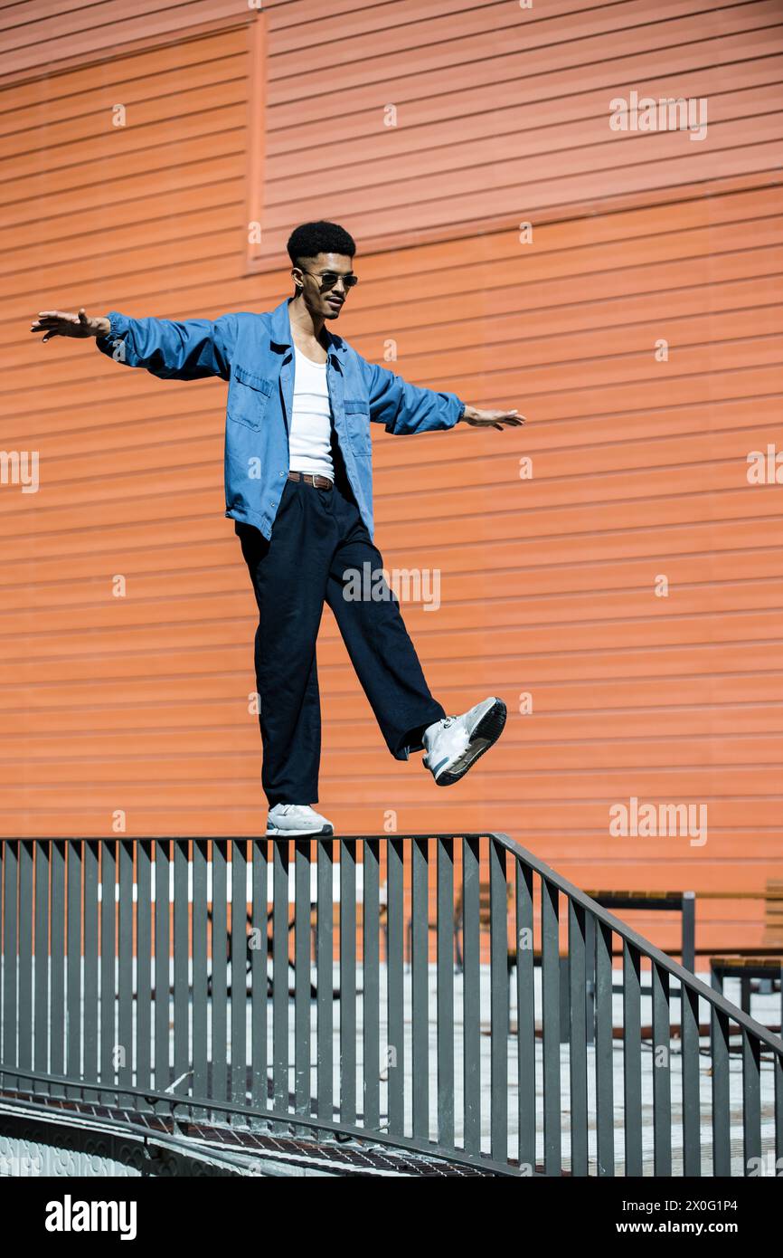 Young relaxed man walking on a handrail Stock Photo - Alamy