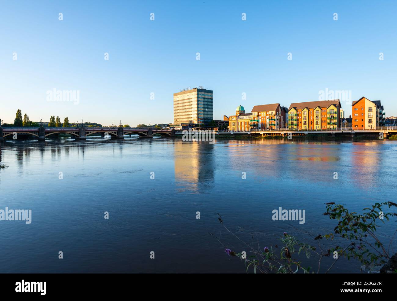 View over the river against buildings in evening sun Stock Photo - Alamy