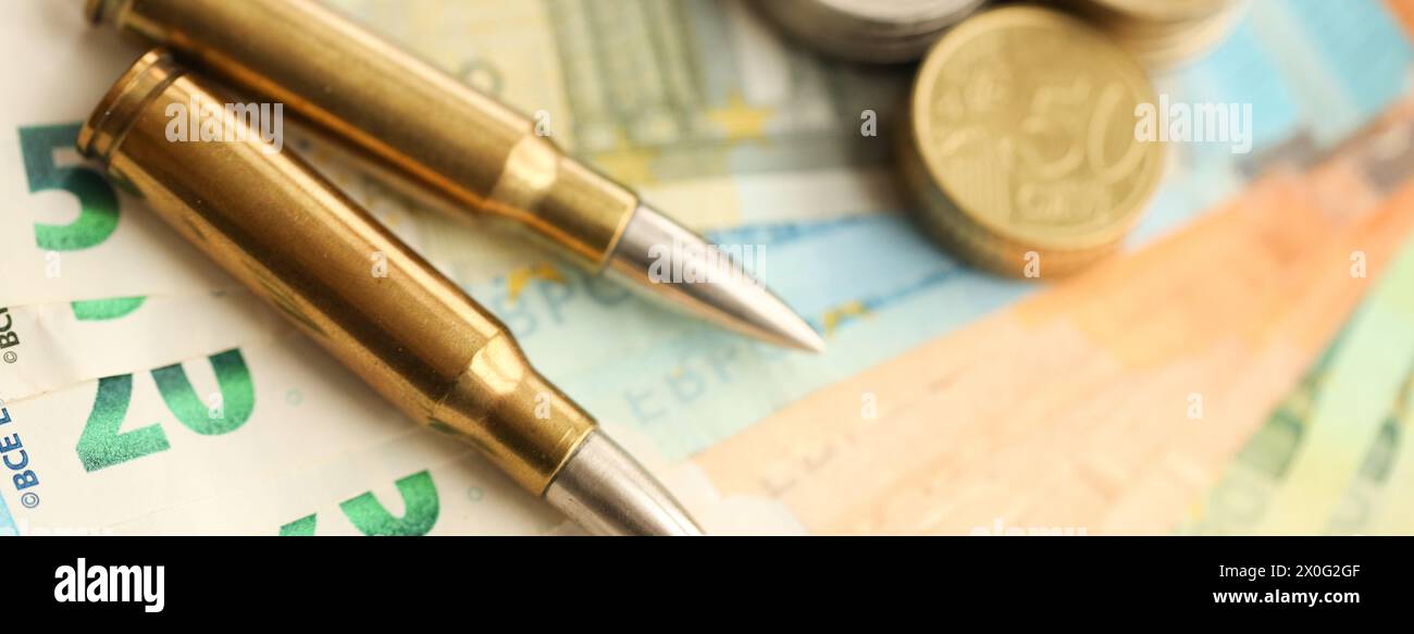 Yellow cartridges and shell casings on euro banknotes. Lot of bills of ...