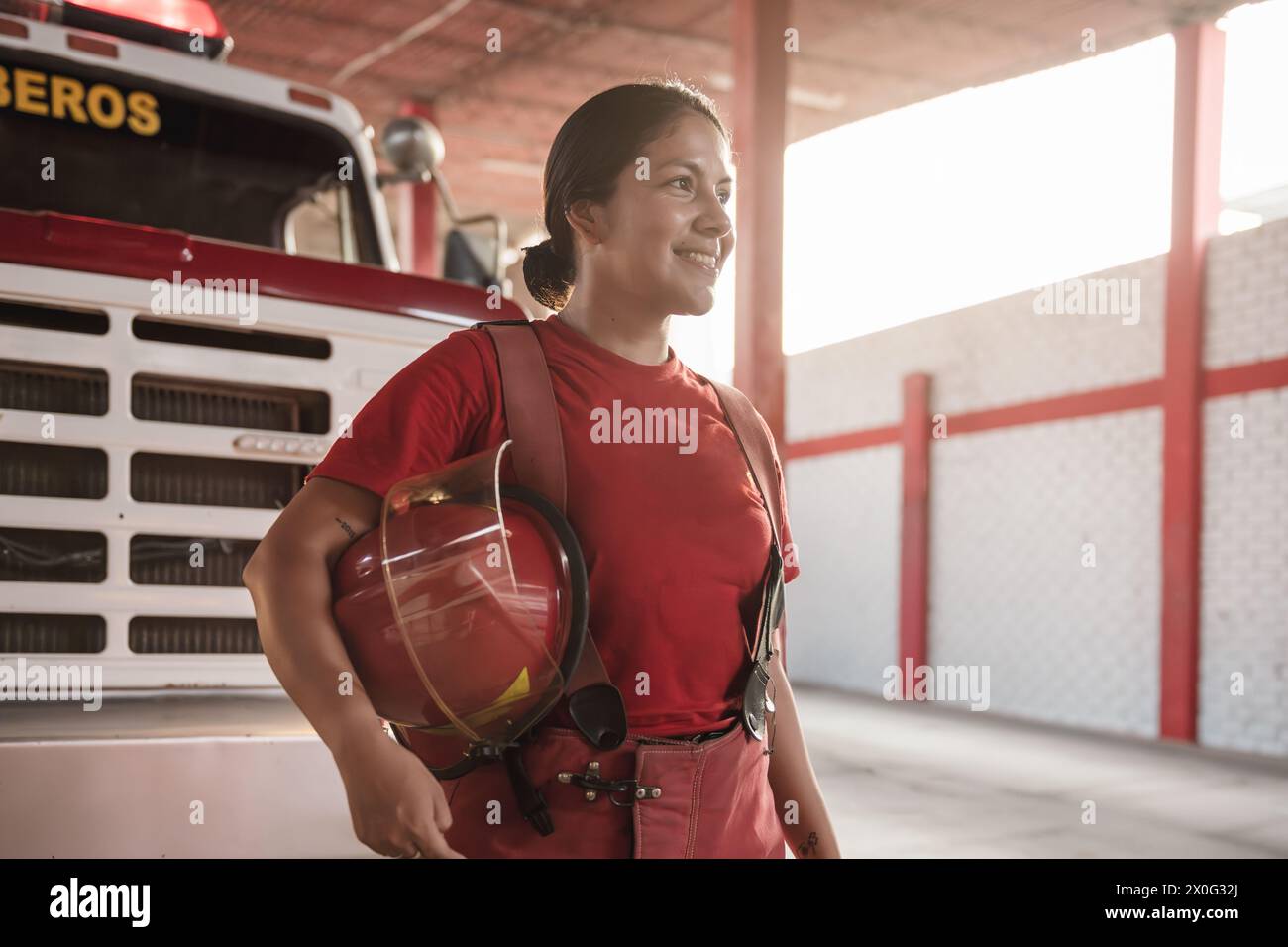 Portrait of happy female firefighter standing at fire station Stock ...