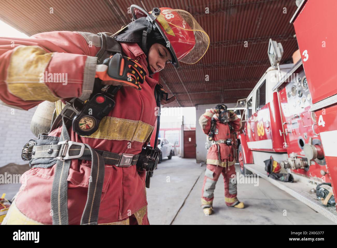 Female firefighter with workwear working at fire engine Stock Photo - Alamy