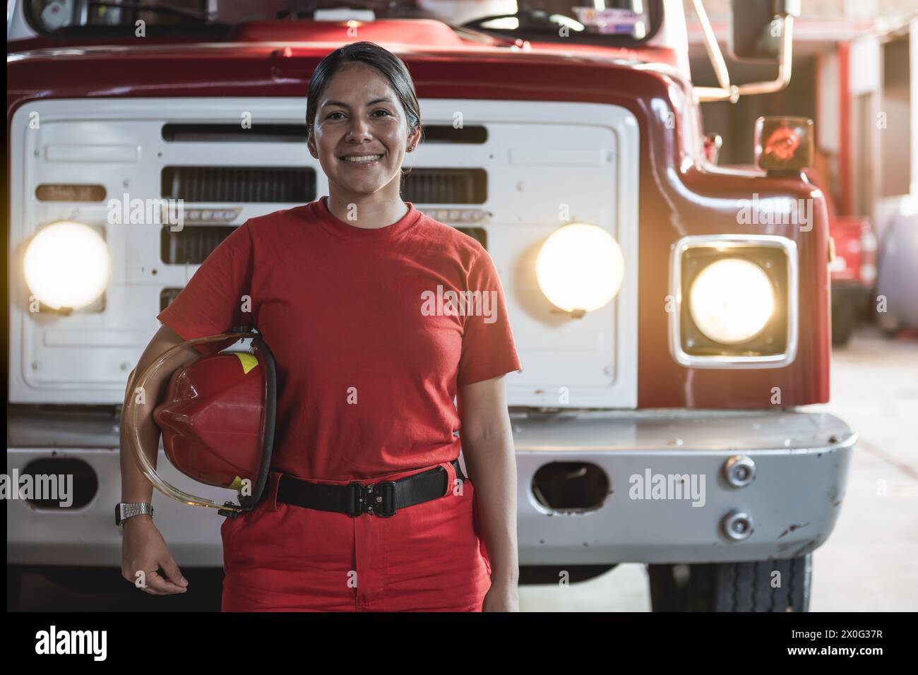 Portrait of smiling female firefighter standing at fire station Stock ...