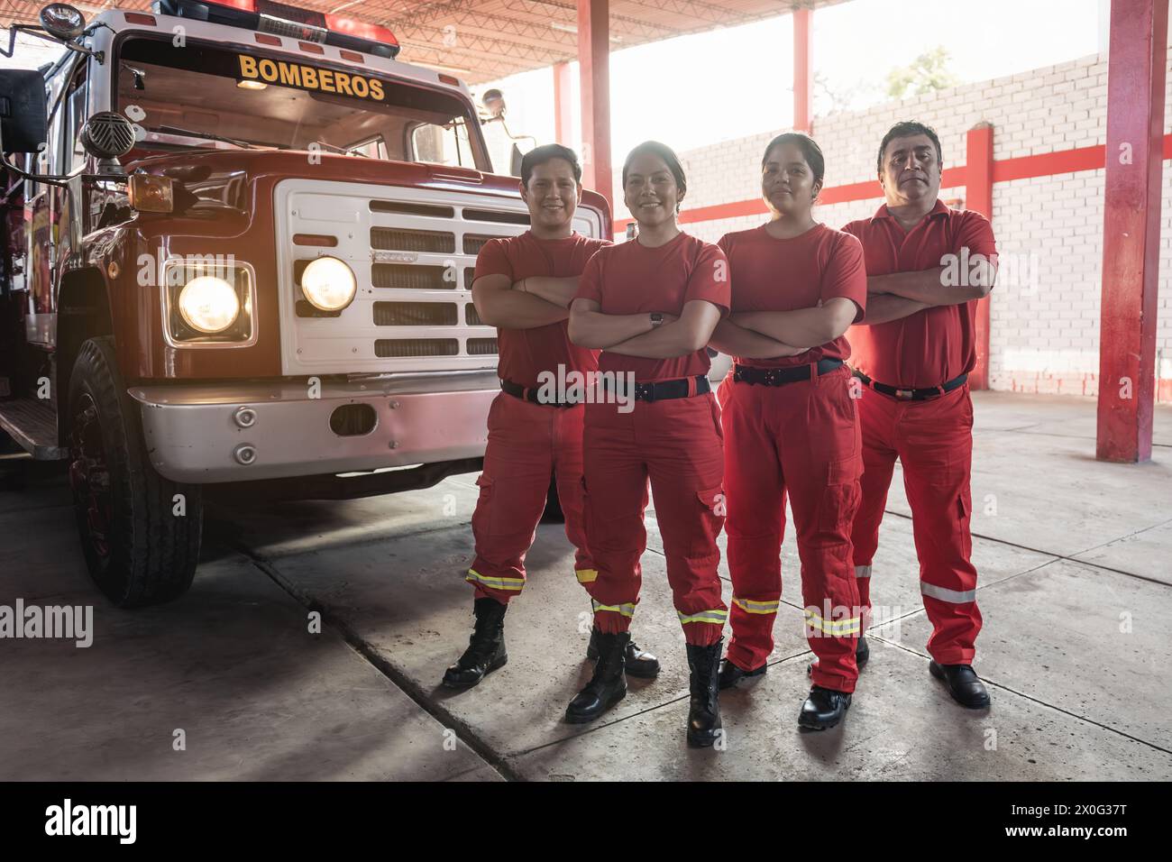 Portrait of a team of male and female firefighters with fire truck ...