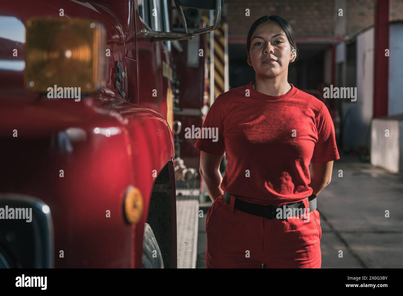 Portrait of smiling female firefighter standing at fire station Stock ...