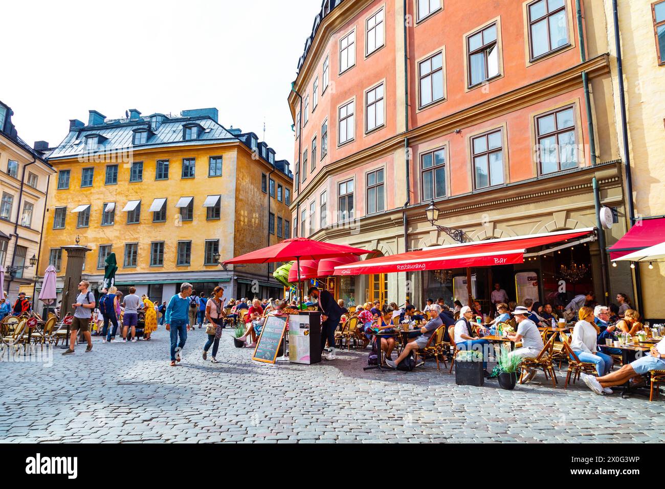People sitting outside at cafes and restaurants in Jarntorget square in ...