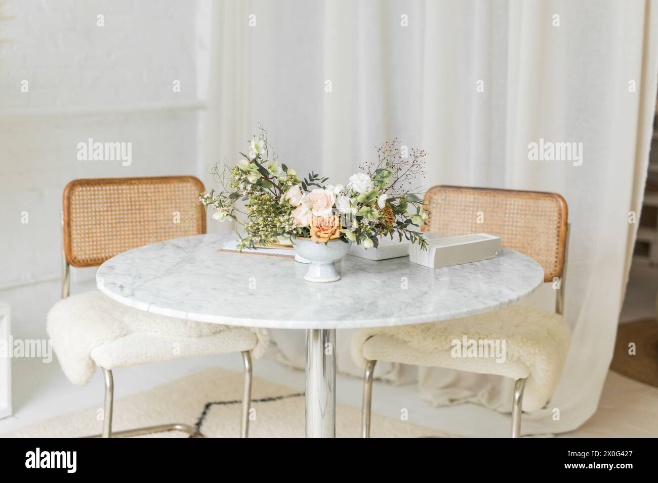Stylish table with flowers and design book Stock Photo - Alamy