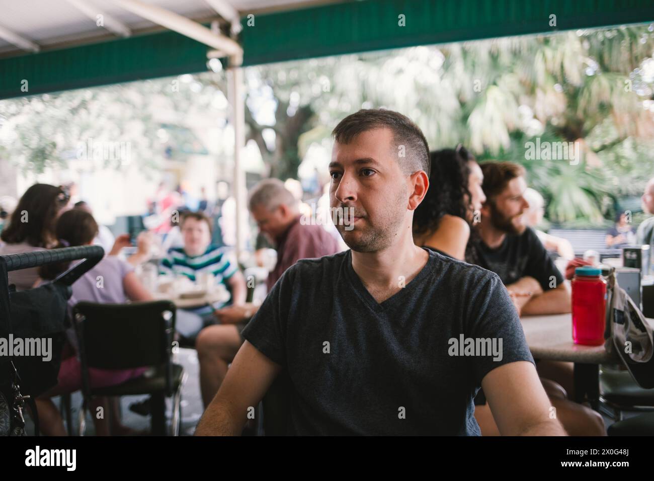 Man sits alone at busy outdoor cafe in New Orleans in July 2017 Stock ...