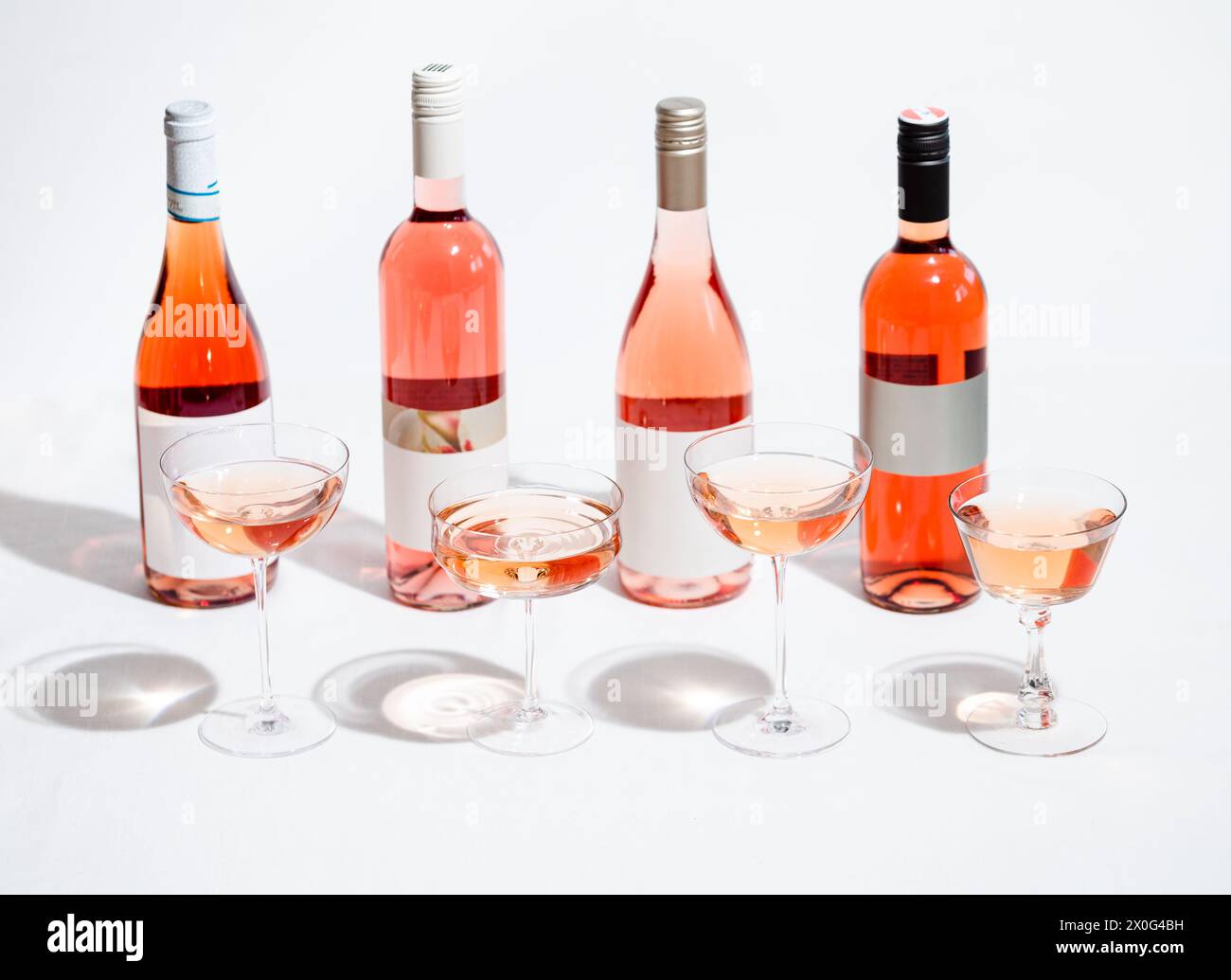 Four varieties of Rose wine bottles poured into different wine g Stock ...