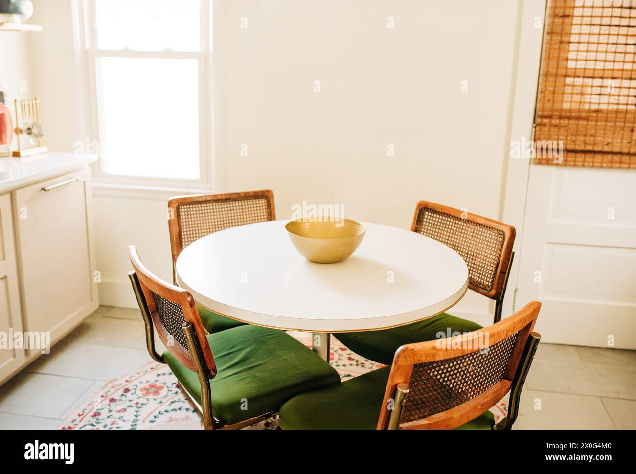 White Table With Four Chairs in a Boho Dining Room Stock Photo - Alamy