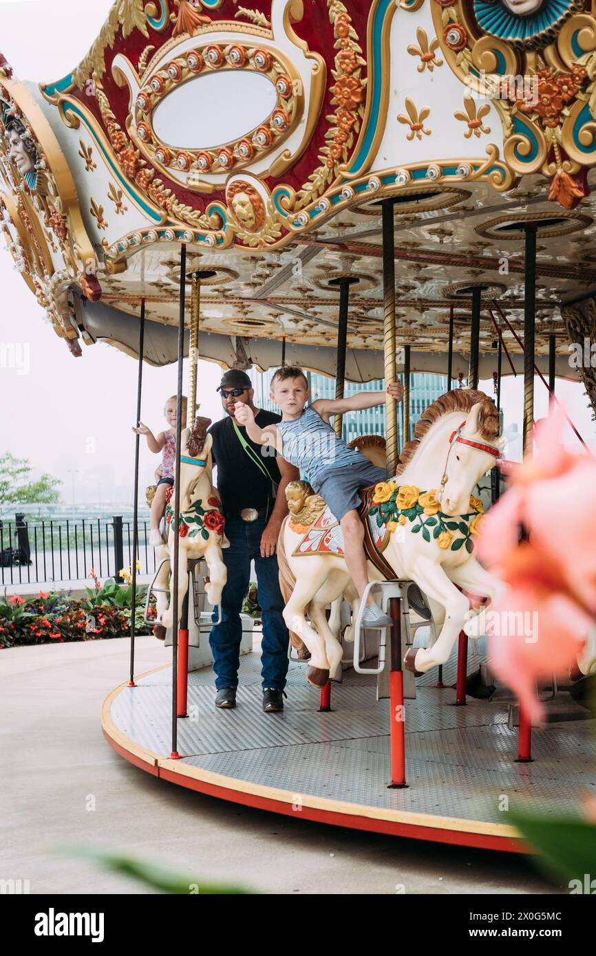 Family enjoying carousel carnival ride in Illinois Stock Photo - Alamy