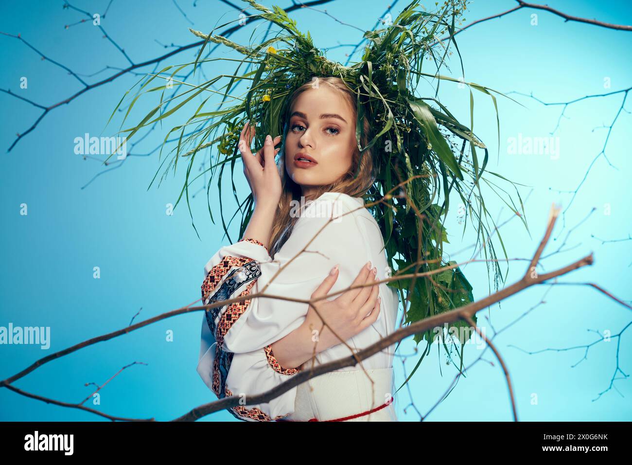 A young woman in a traditional outfit, stands under a tree in a fairy ...
