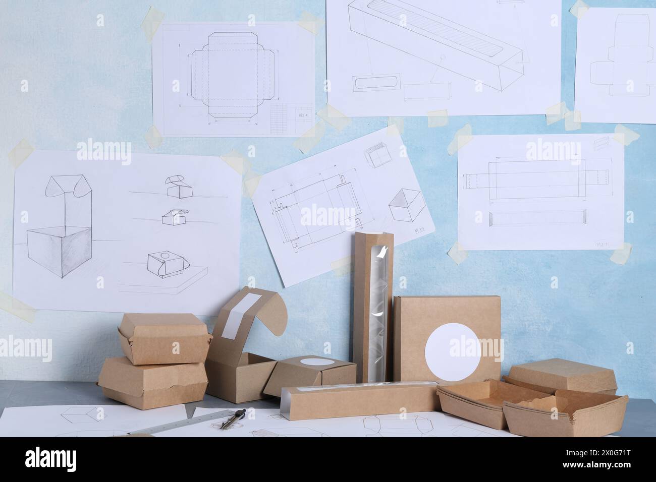 Creating packaging design. Drawings, boxes and stationery on table ...