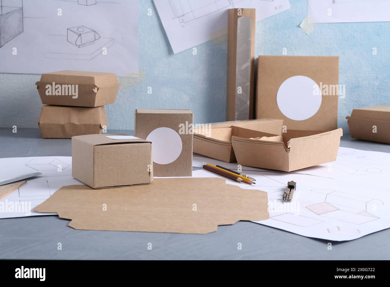 Creating packaging design. Drawings, boxes and stationery on blue ...