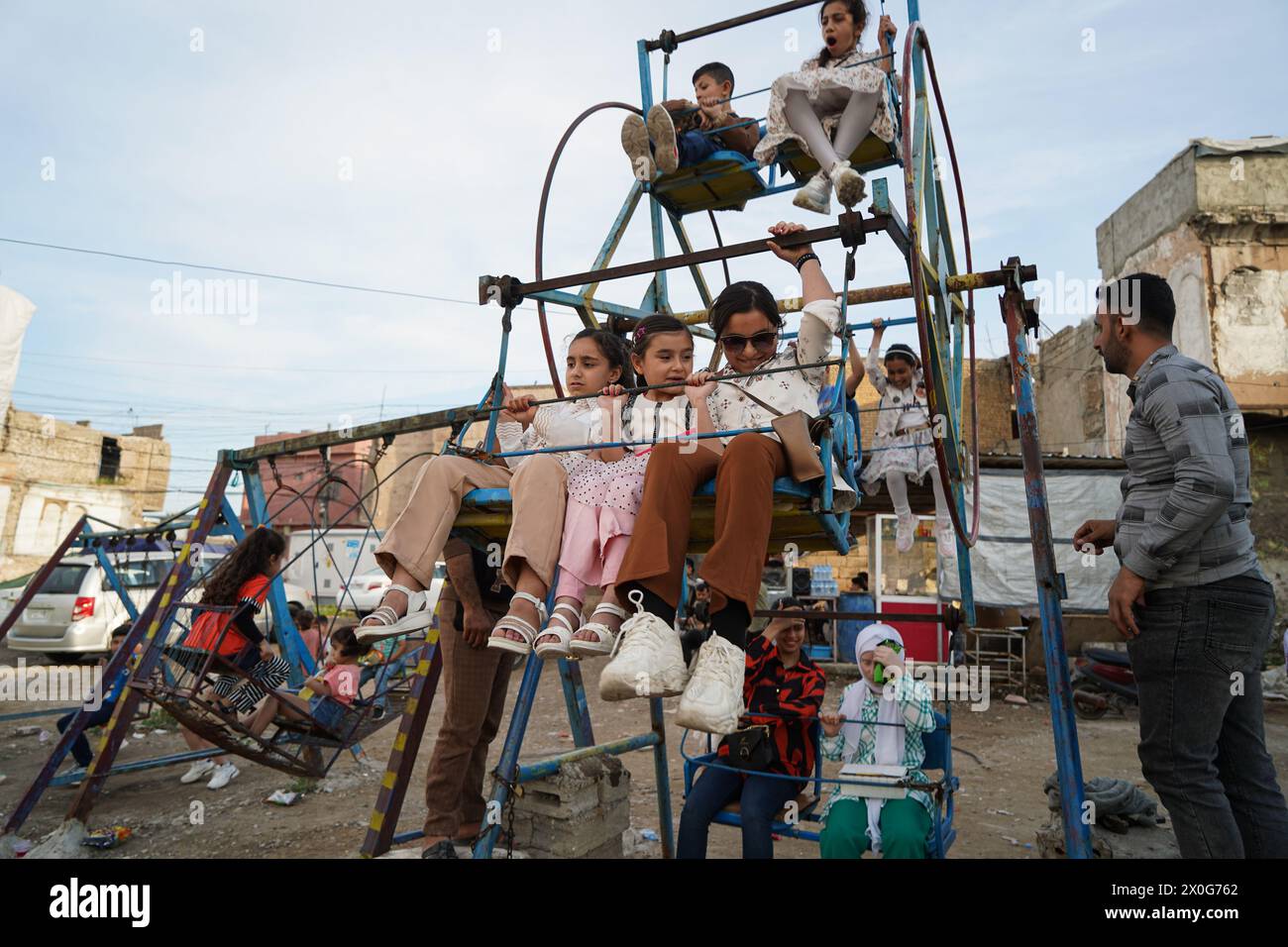 Mosul, Iraq. 11th Apr, 2024. Iraqi children play on a hand-powered ...