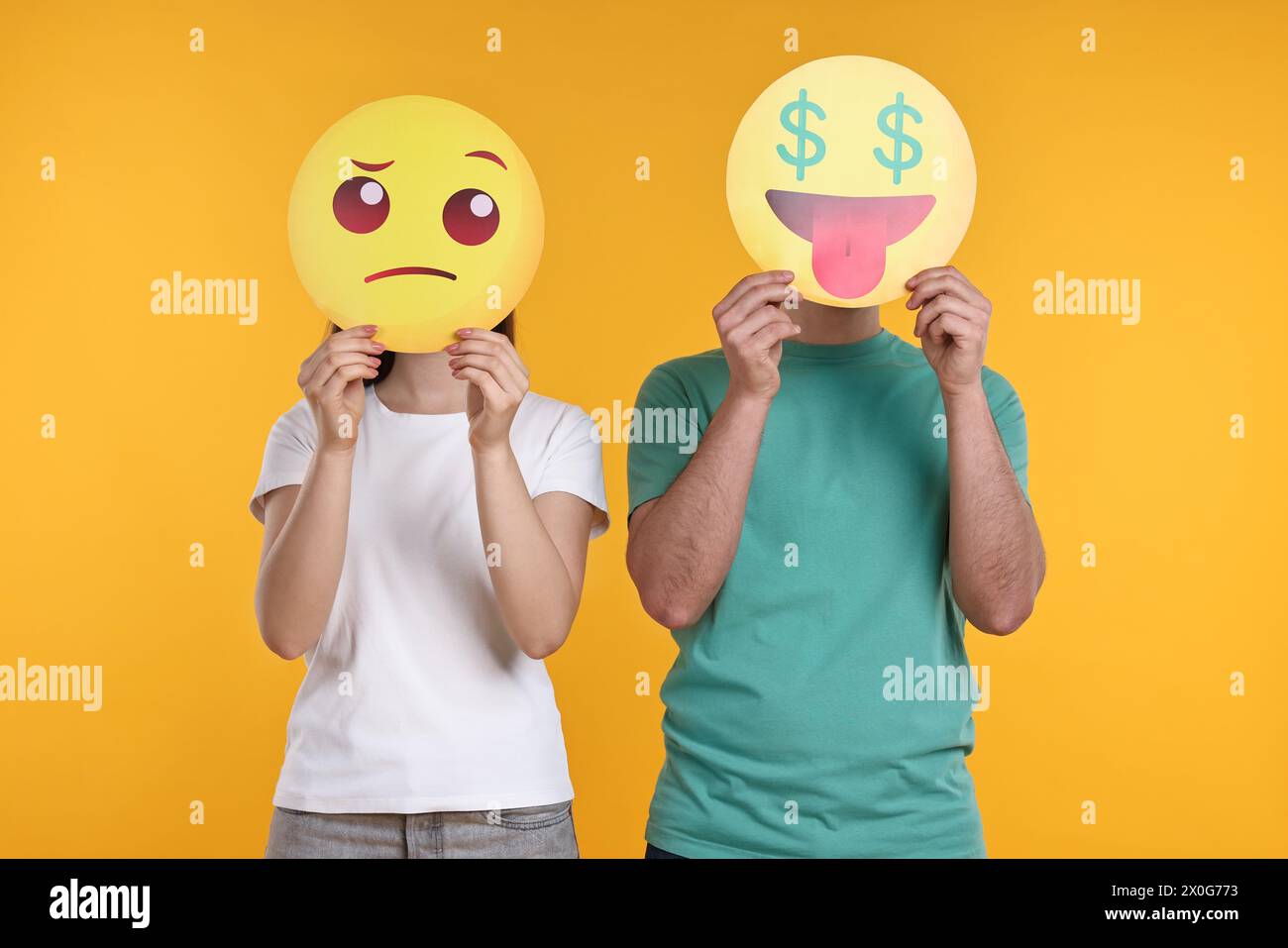 People covering faces with emoticons on yellow background Stock Photo ...