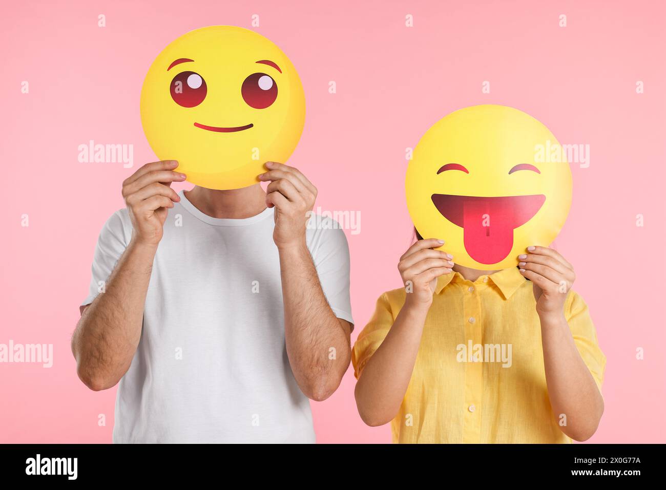 People covering faces with emoticons on pink background Stock Photo - Alamy