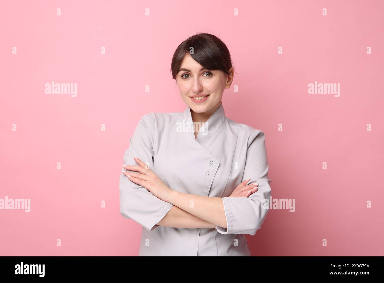 Cosmetologist in medical uniform on pink background Stock Photo - Alamy