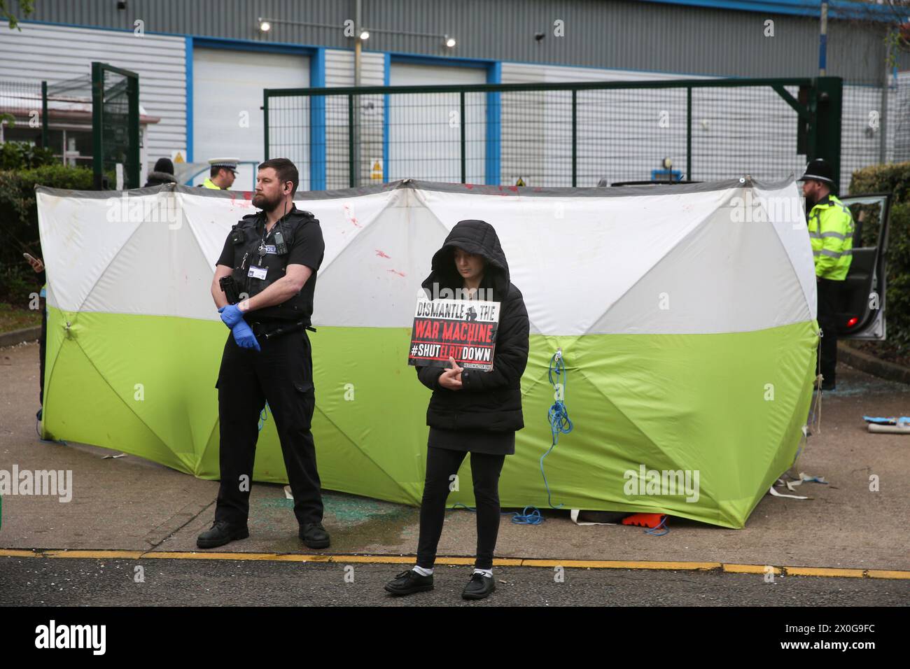A protester stands holding a sign that says "Dismantle The War Machine ...
