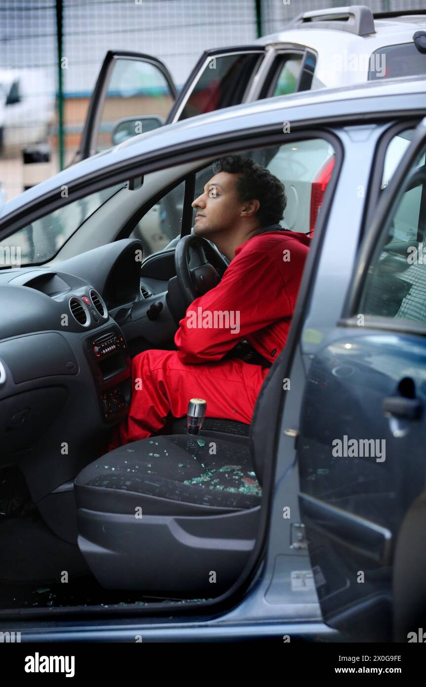 An activist wearing the red jumpsuit of Palestine Action sits attached ...