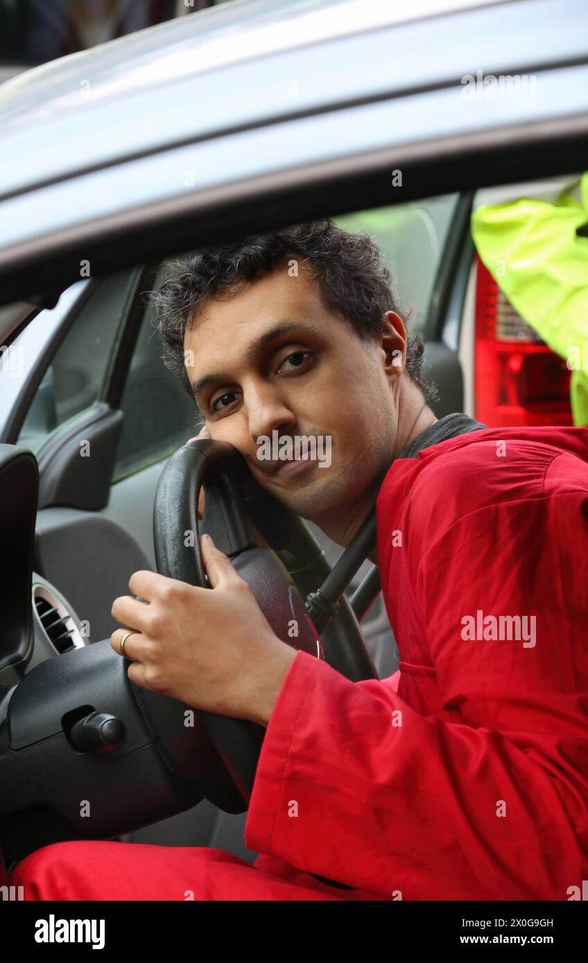 An activist wearing the red jumpsuit of Palestine Action sits attached ...