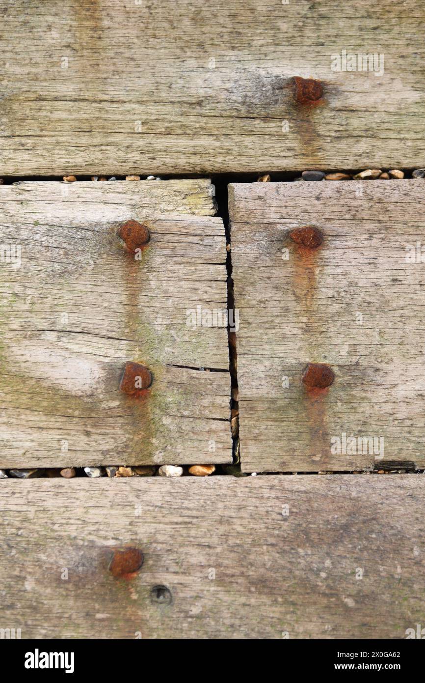 Close up of wooden groyne or breakwater on beach showing rusty rusting ...