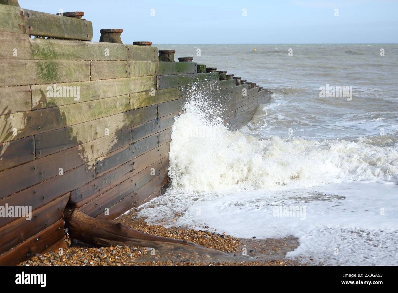 Wooden breakwater or groyne with waves from English Channel breaking ...