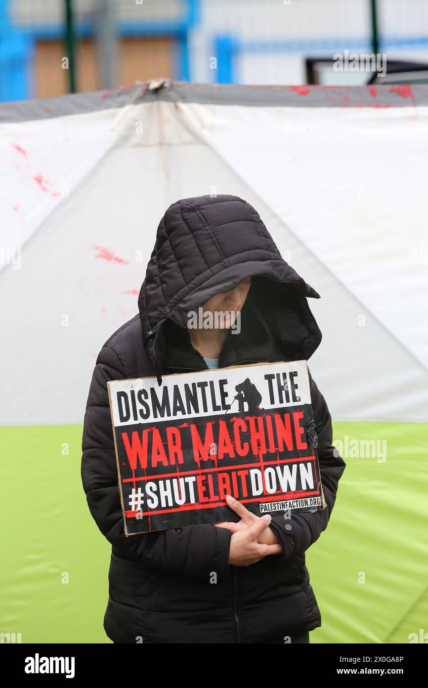 A protester stands holding a sign that says "Dismantle The War Machine ...