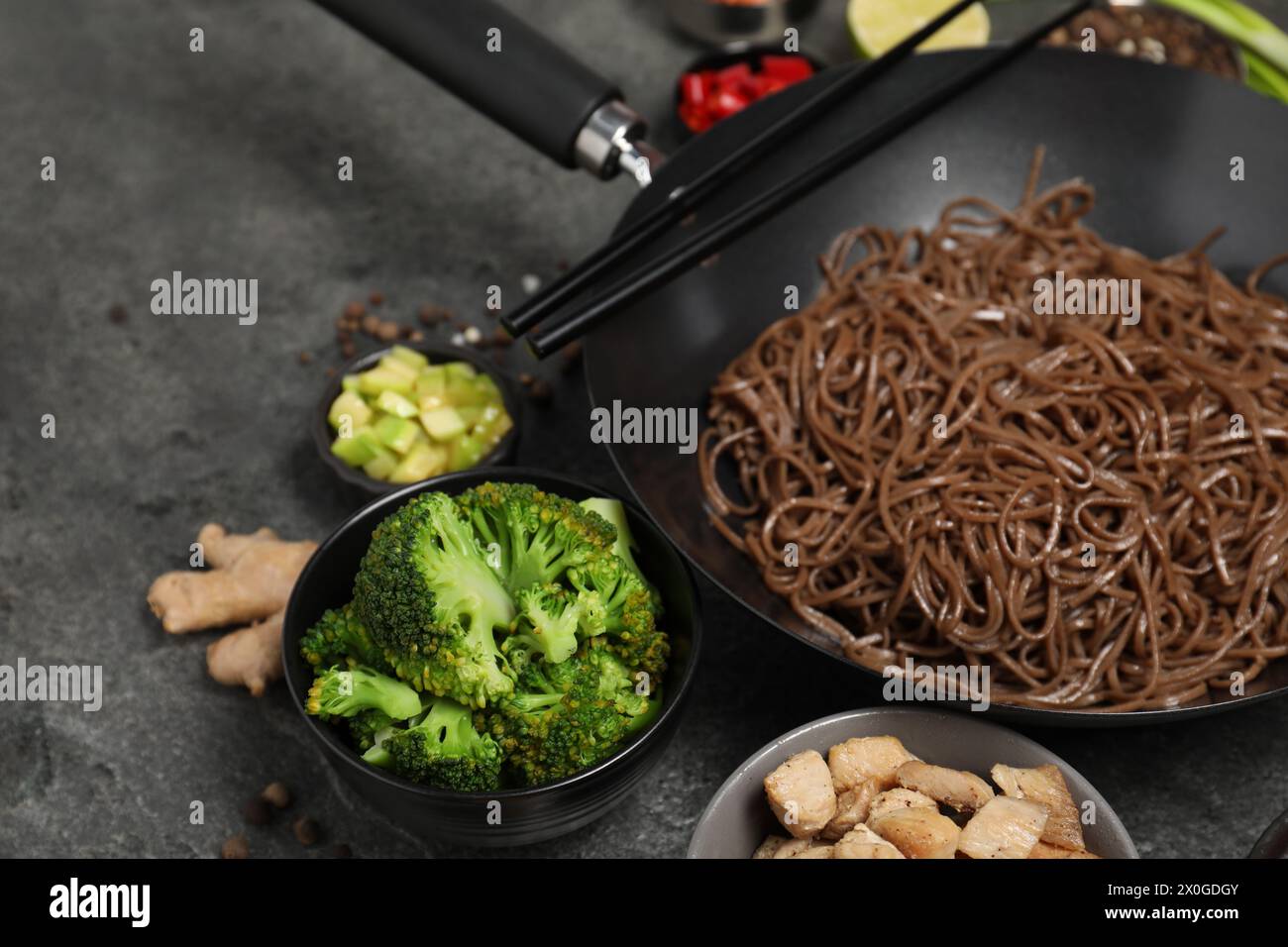 Wok with noodles, chicken and other products on grey table Stock Photo ...