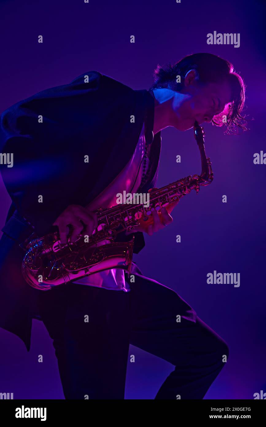 Young man, talented, charismatic solo player in black suit playing sax ...
