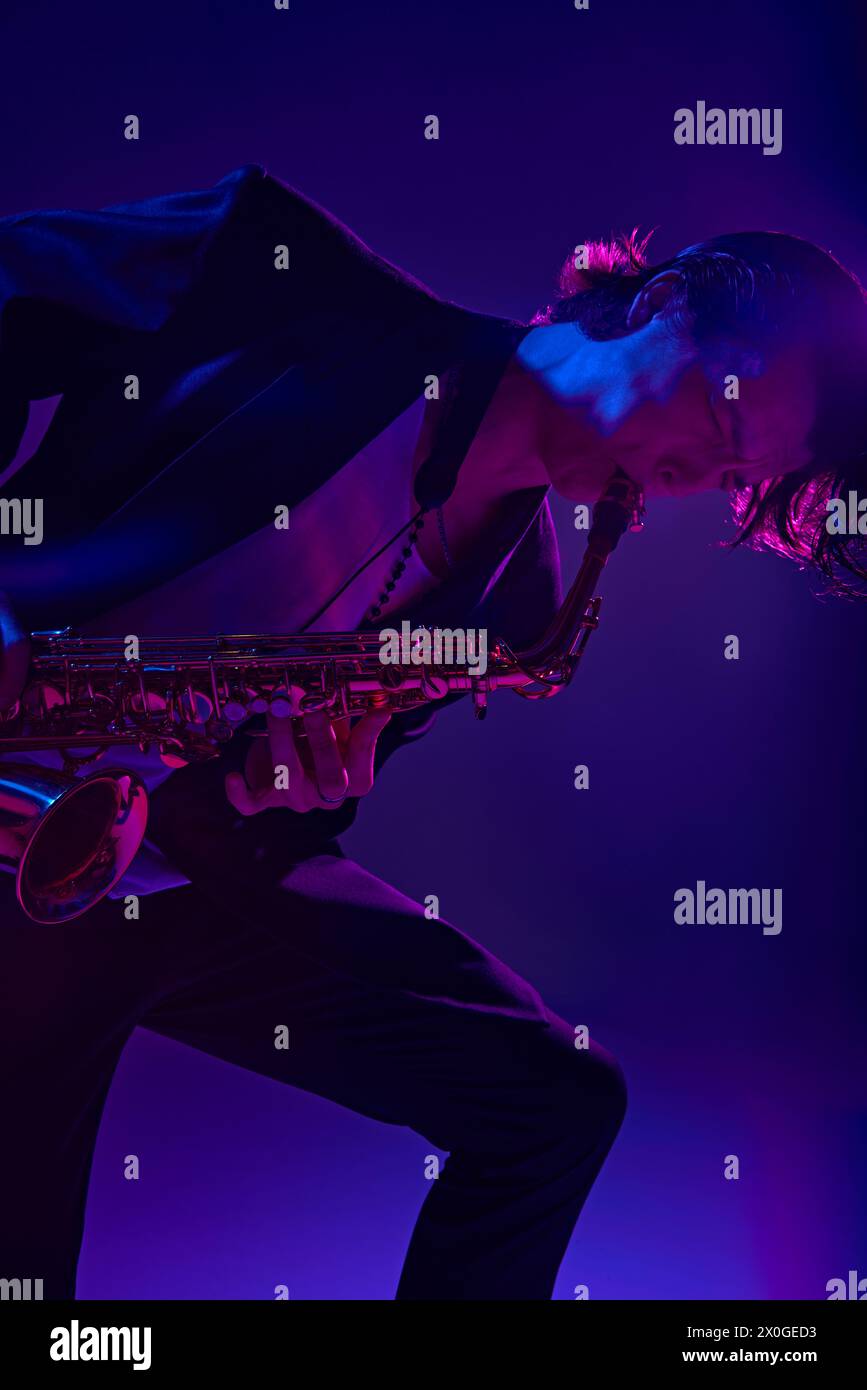 Young virtuoso in classical black suit playing saxophone in vibrant ...