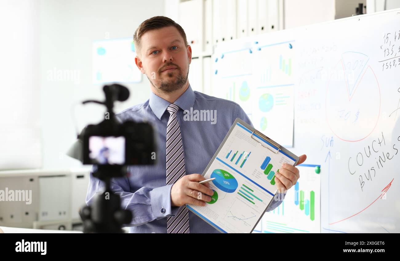 Male in suit and tie show stats graph pad Stock Photo - Alamy