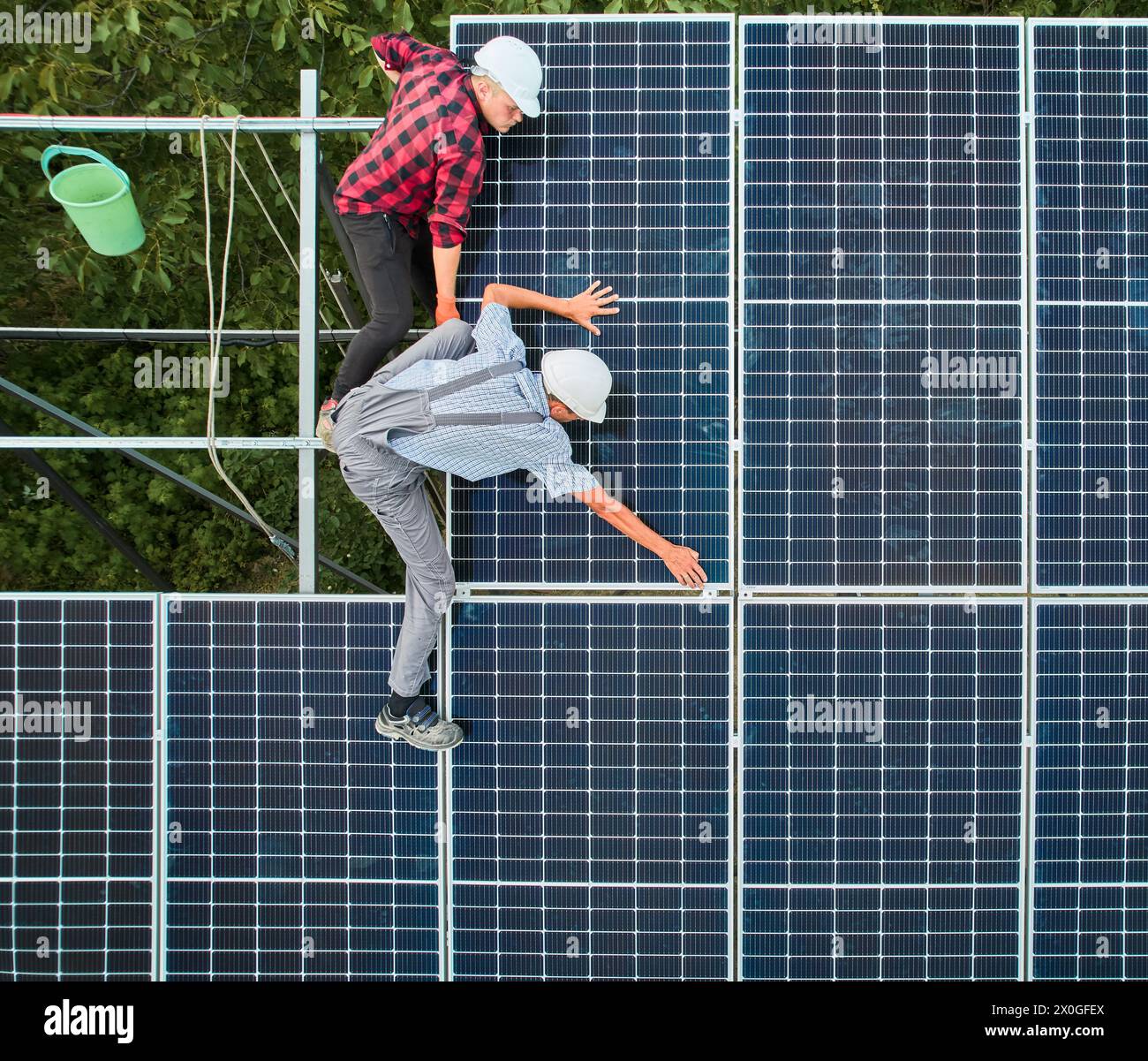 Aerial view of men technicians installing photovoltaic solar panels to ...
