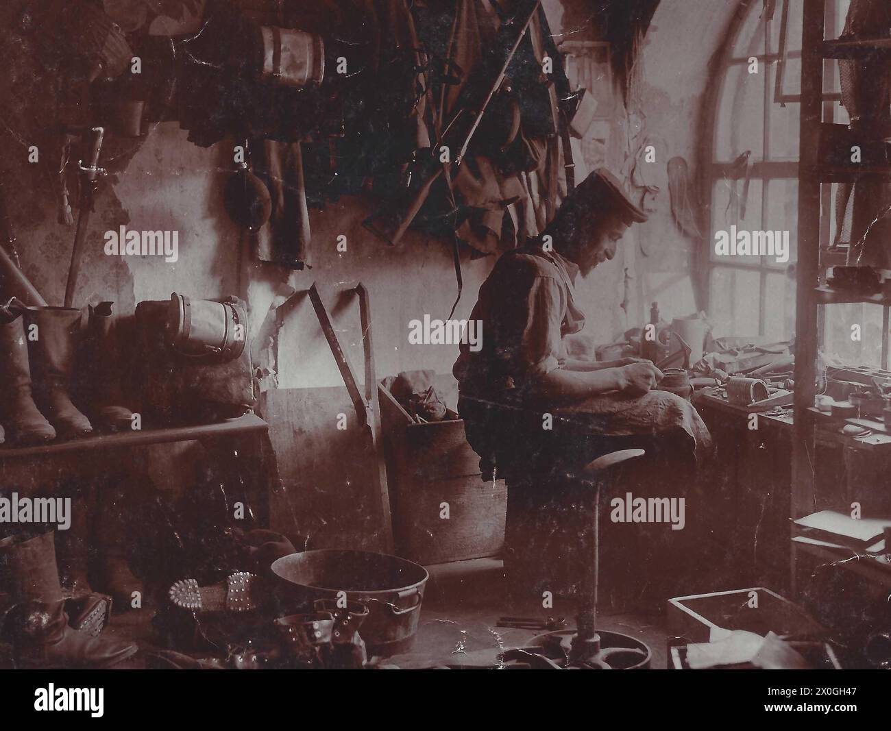 The company cobbler sits at his workstation in front of an arched ...