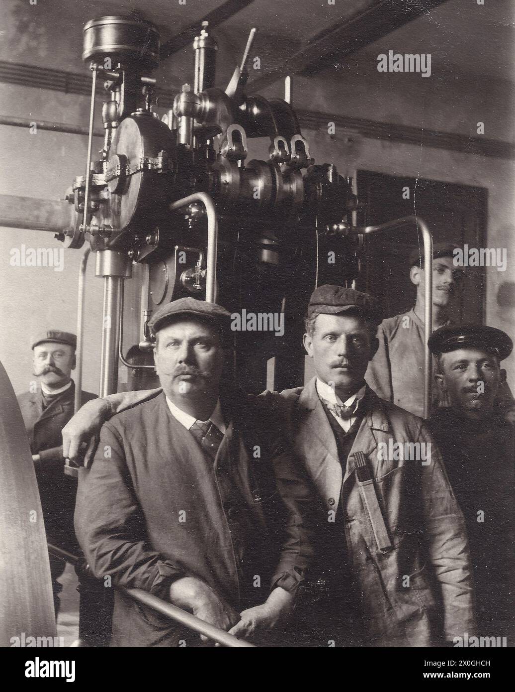 Workers of a machine hall have lined up in front of a machine. Place ...
