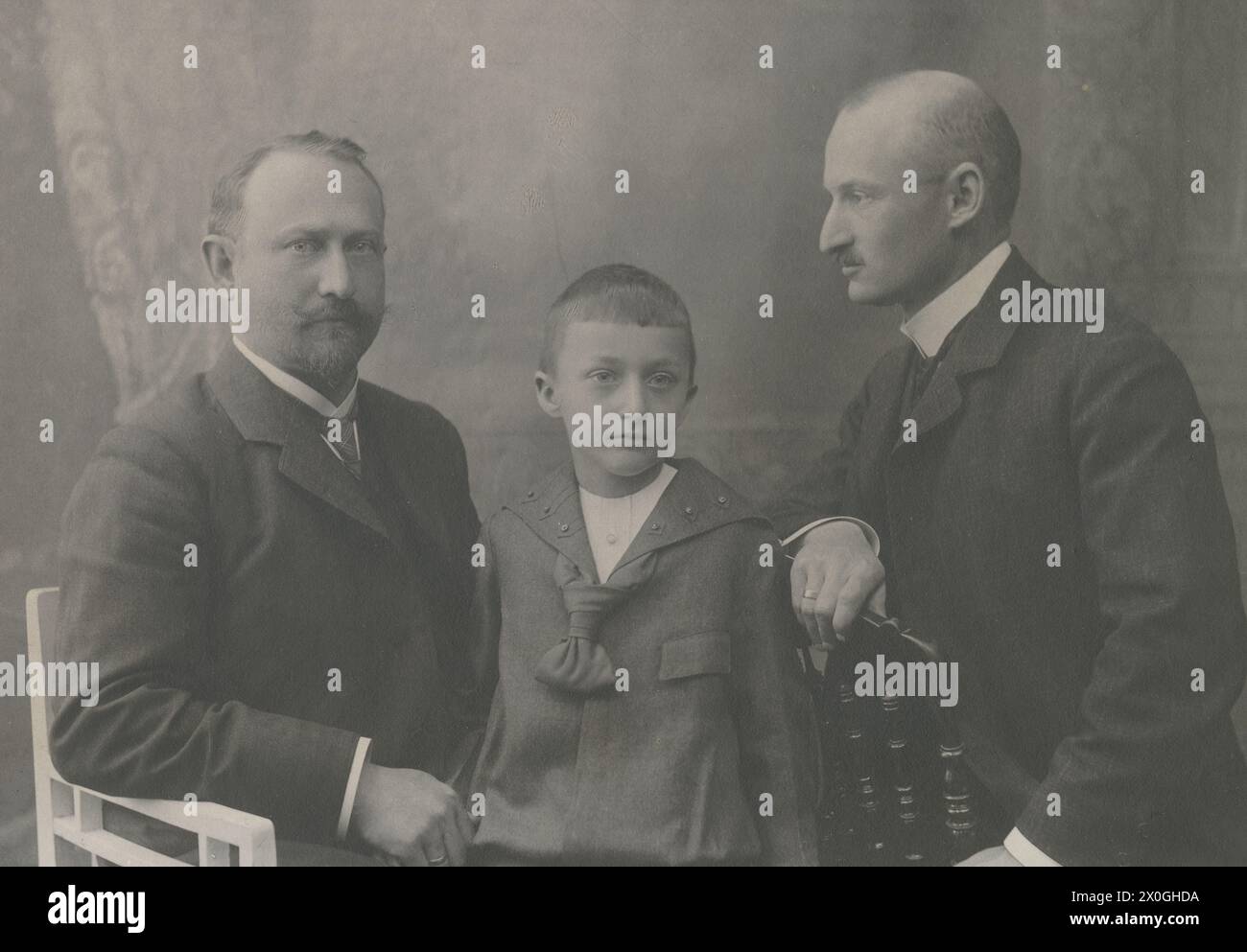 2 men and a boy of about 8 years standing in the center of the picture ...