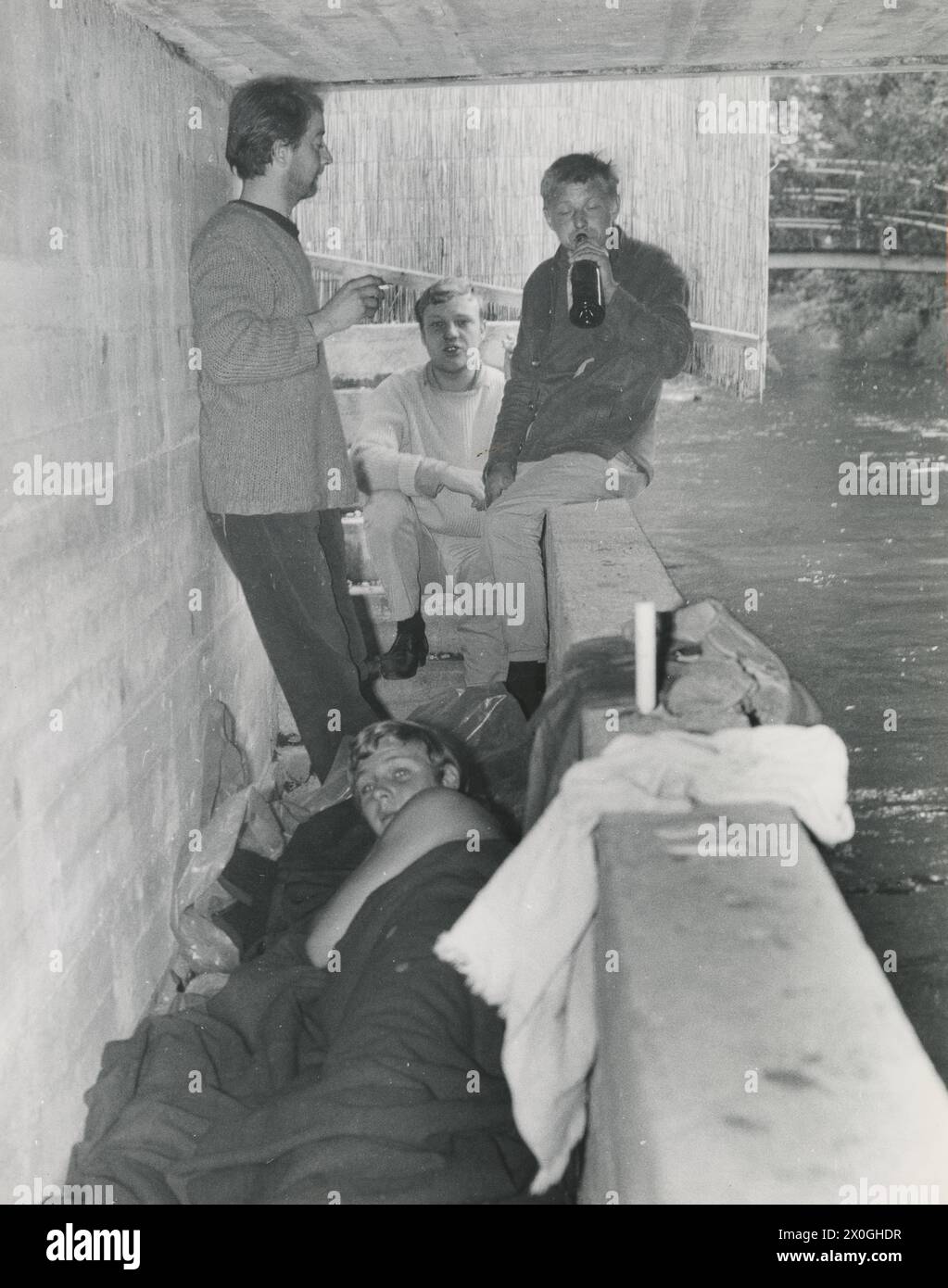4 Munich homeless people (approx. 18-40 years old) sit and stand under ...
