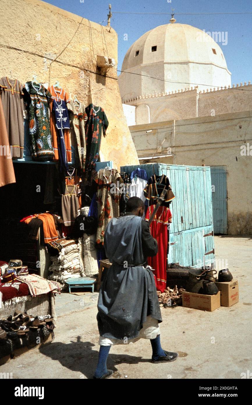 A man passes a clothes shop in a market in El Qued. [automated ...