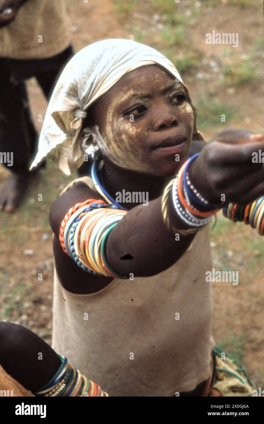 A woman from the Xhosa ethnic group with face painting and bracelets in ...